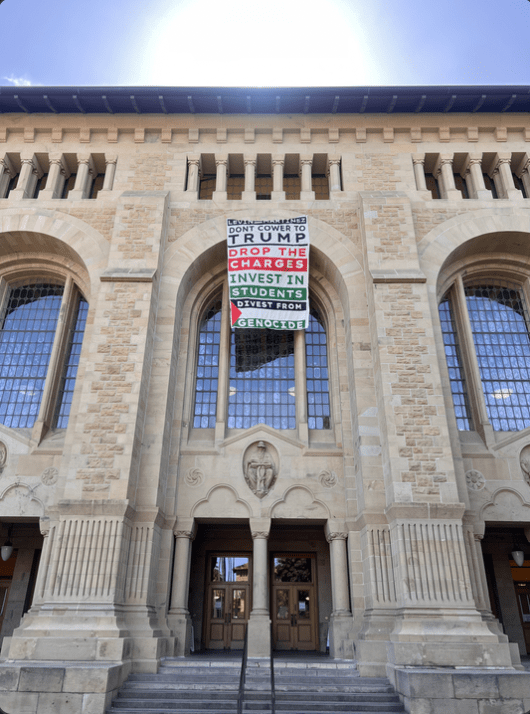 Student activists mount protest banner over Green Library